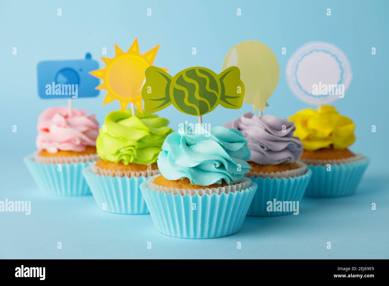 Tasty cupcakes with stylish toppers on color background Stock Photo - Alamy