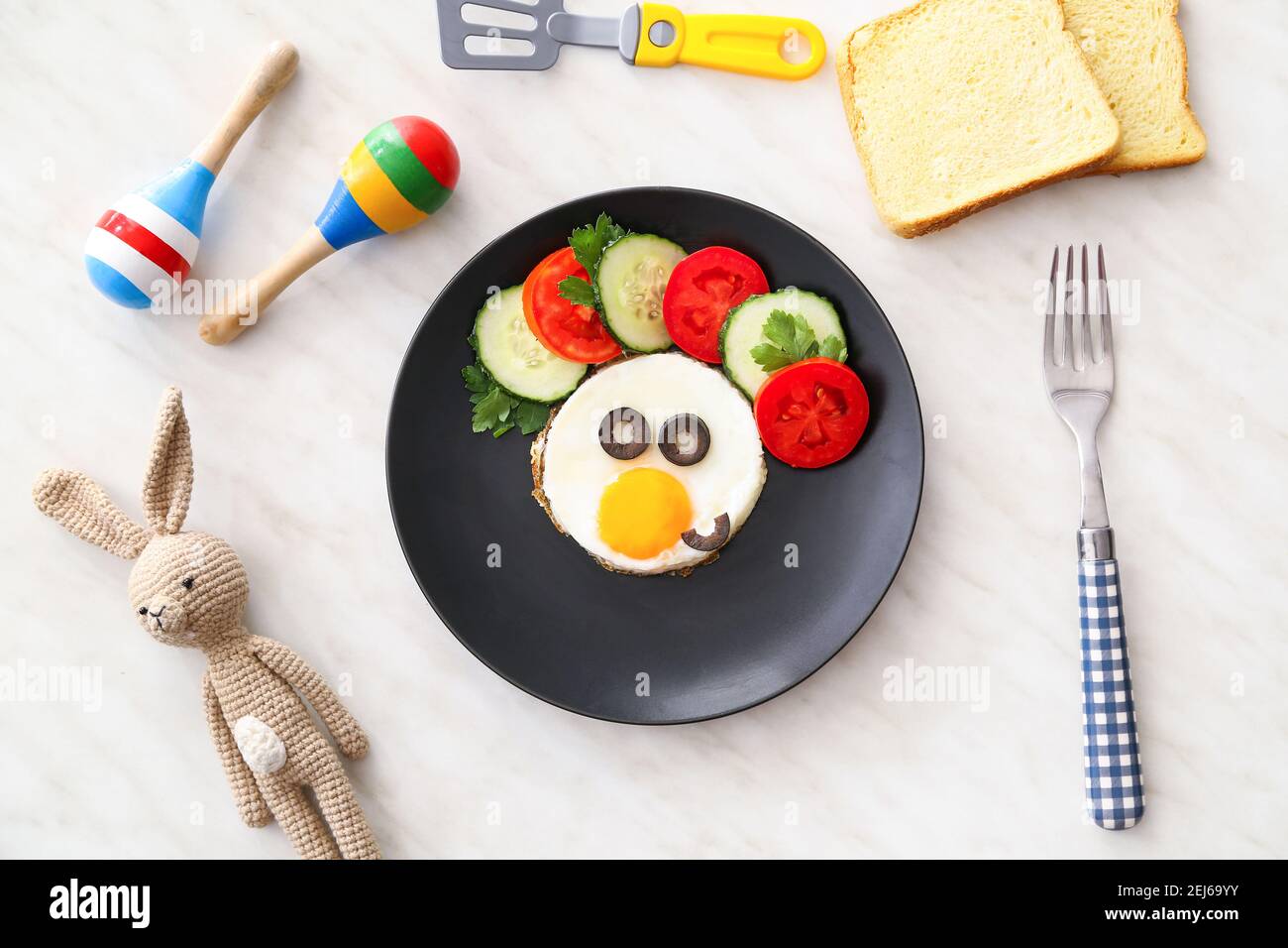 Creative breakfast for children with egg, fresh vegetables and toys on ...