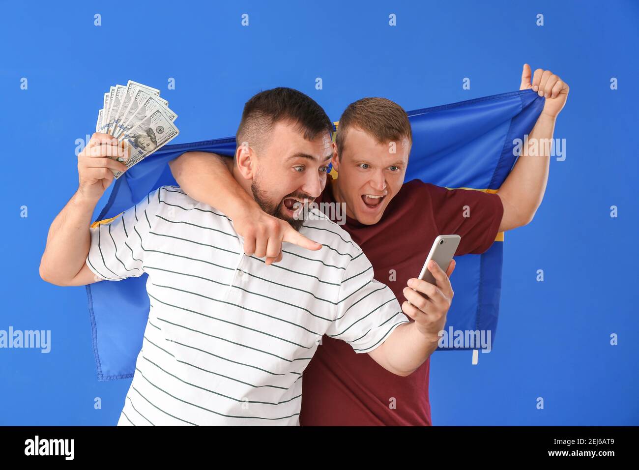 Happy men after winning of their sports bet on color background Stock ...