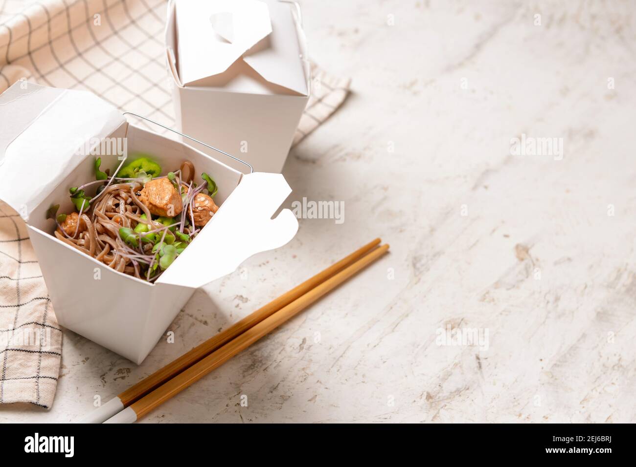 Container with tasty soba noodles and meat on light background Stock ...