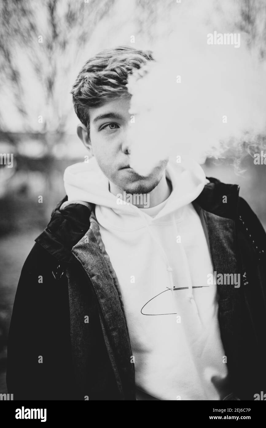 Young guy blowing smoke; smoking addiction Stock Photo - Alamy