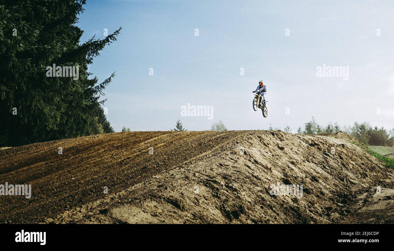 Motocross rider in the race making a stunt and jumping in the air Stock ...