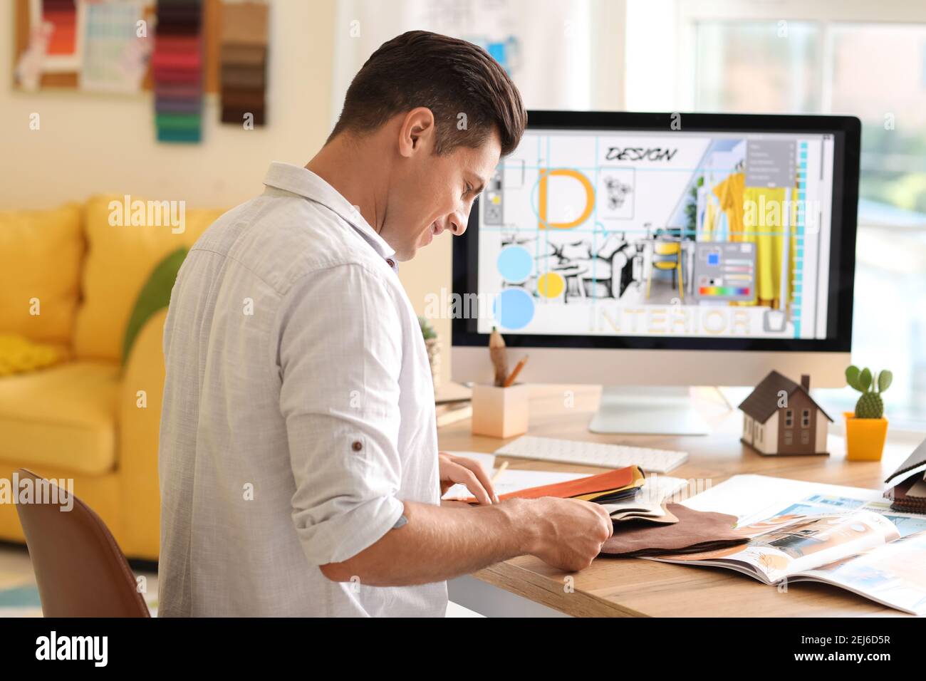 Male interior designer working in his office Stock Photo - Alamy