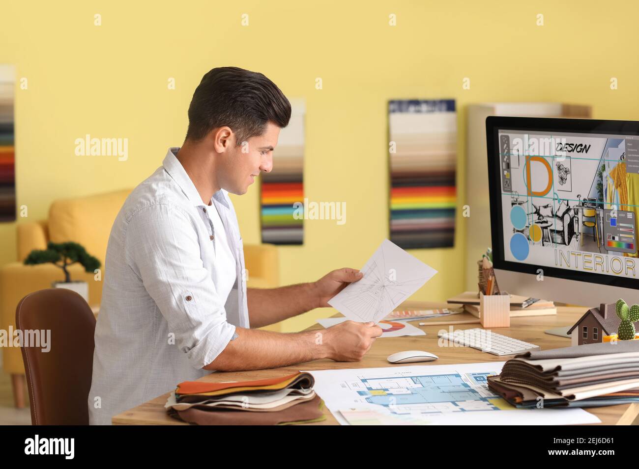 Male interior designer working in his office Stock Photo - Alamy