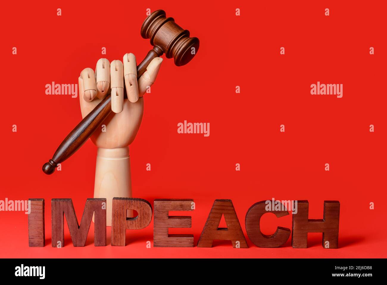 Wooden hand with judge gavel and word IMPEACH on color background Stock ...