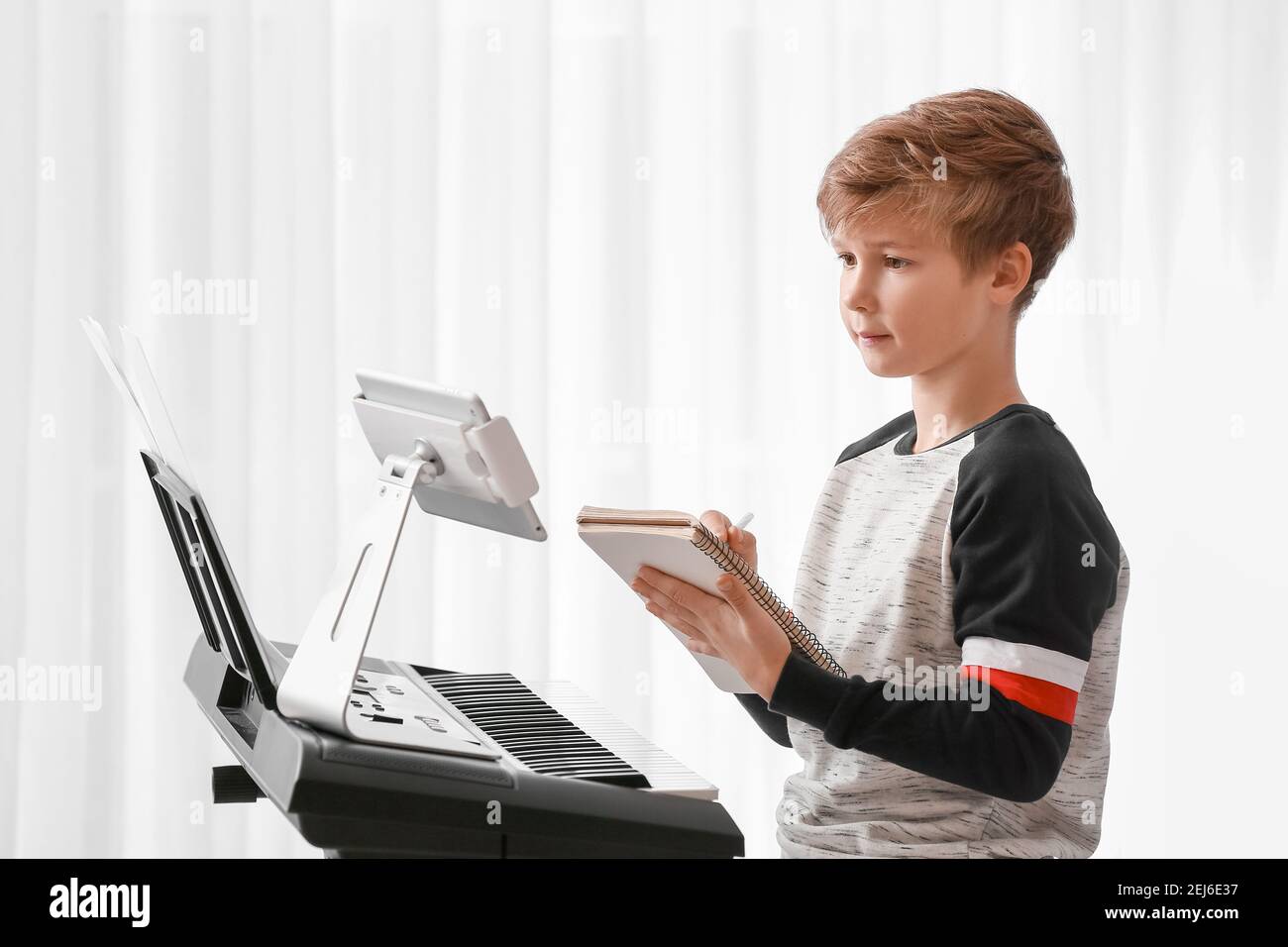 Little boy taking music lessons online at home Stock Photo - Alamy