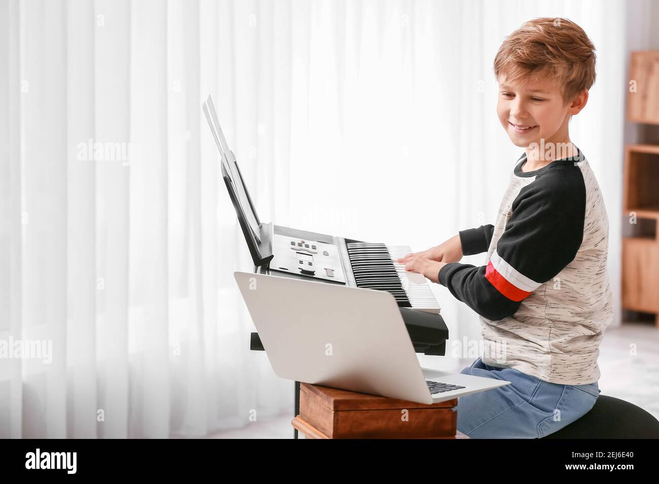 Little boy taking music lessons online at home Stock Photo - Alamy