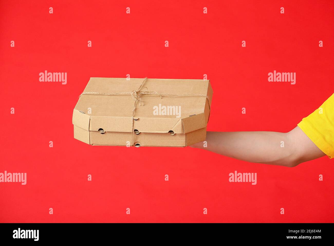 Hand of courier with pizza boxes on color background Stock Photo - Alamy