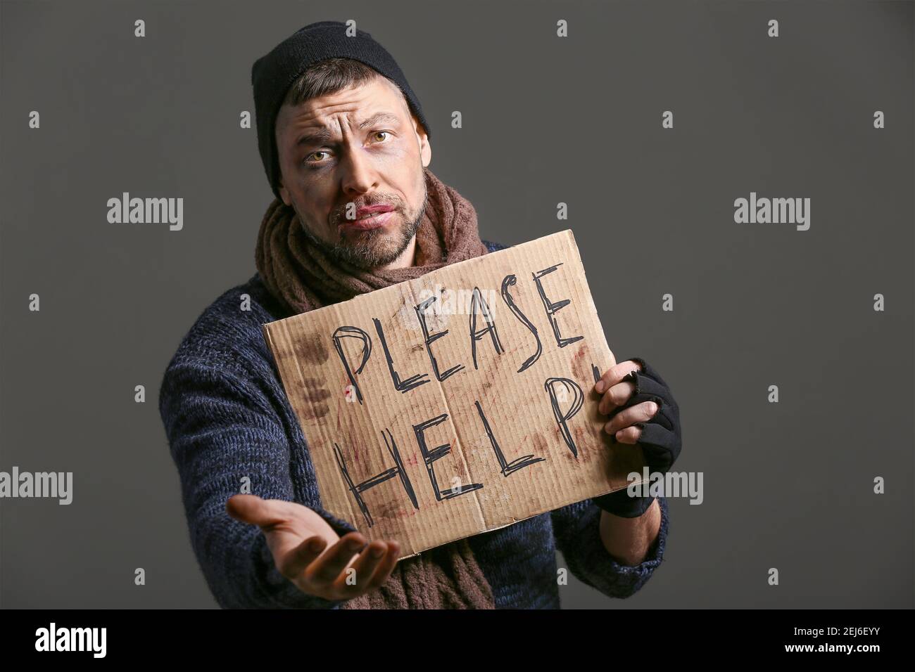 Portrait of begging homeless man on dark background Stock Photo - Alamy