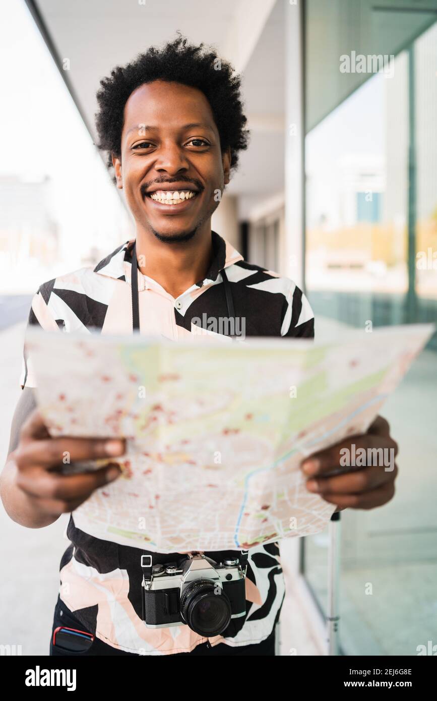 Tourist man looking for directions on map Stock Photo - Alamy