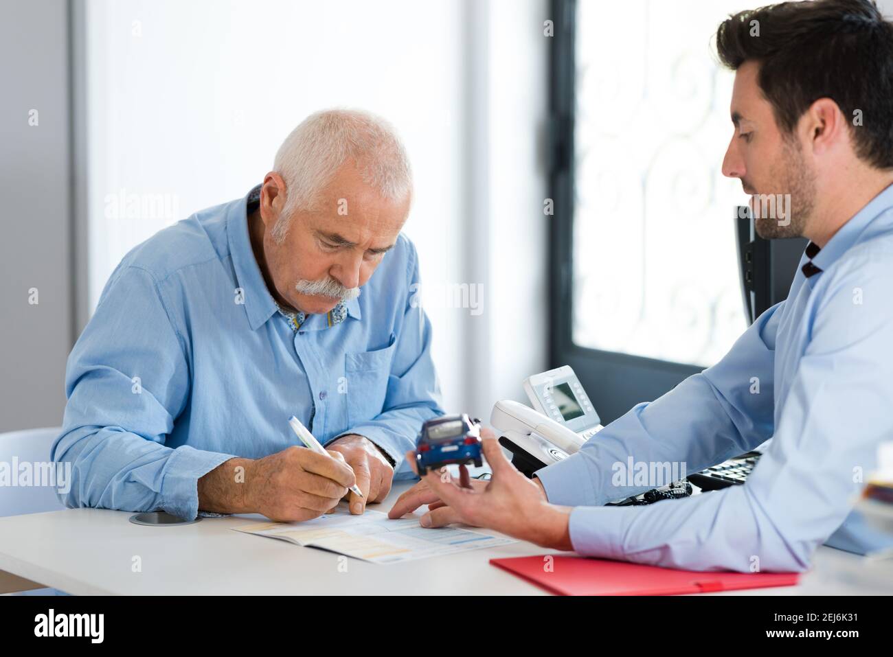 client signing a car insurance deal Stock Photo - Alamy