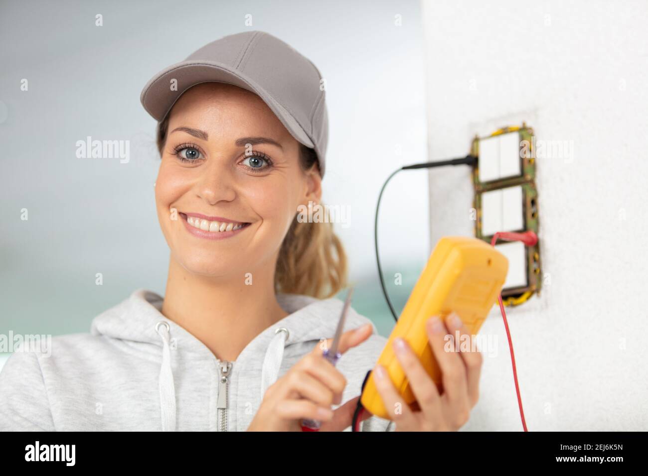 female electrician using meter for light switch Stock Photo - Alamy