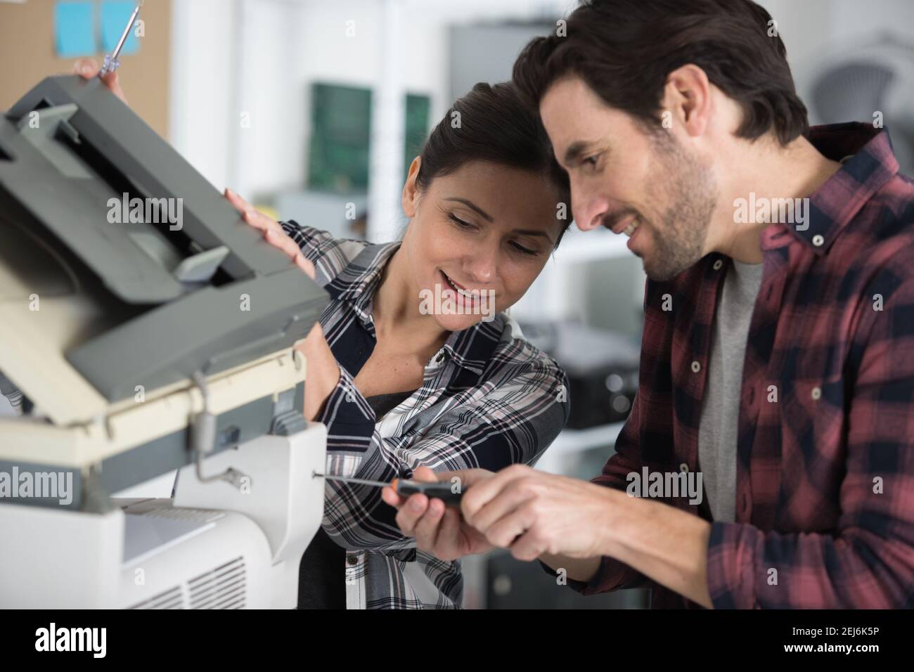 workers fixing a printer together Stock Photo - Alamy