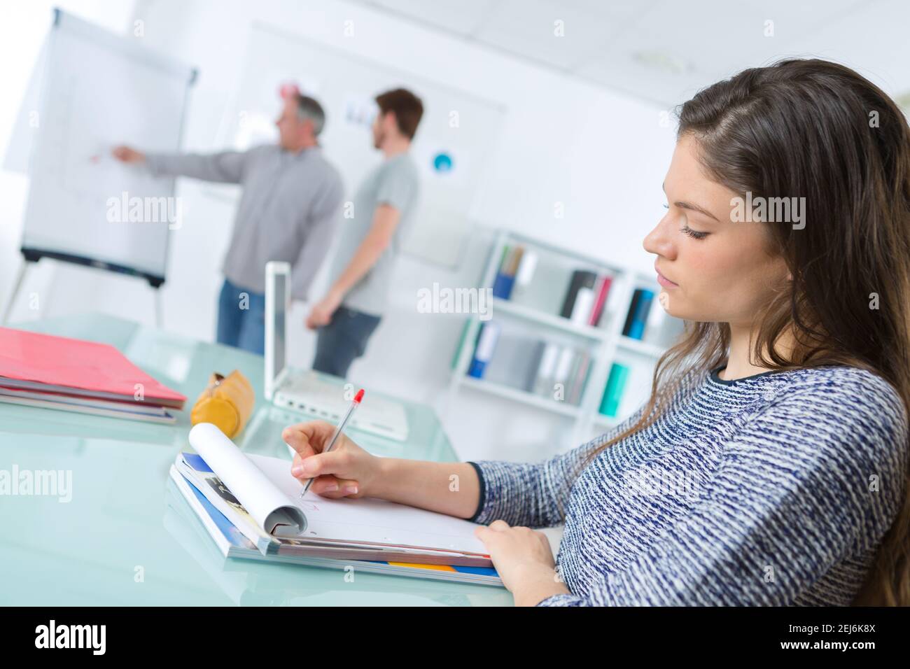 careful female student taking notes in class Stock Photo - Alamy