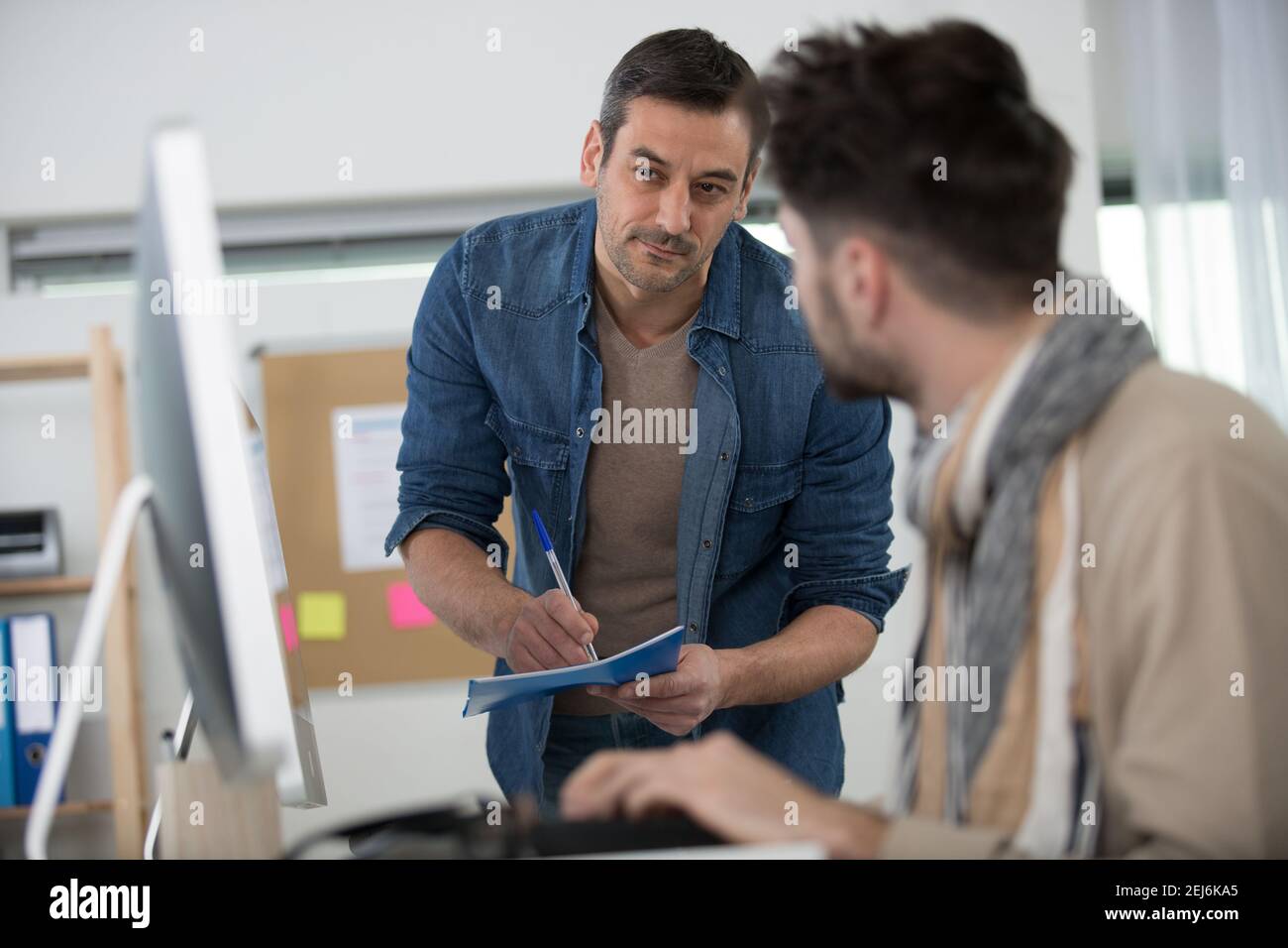 teacher checking students work on computer screen Stock Photo - Alamy