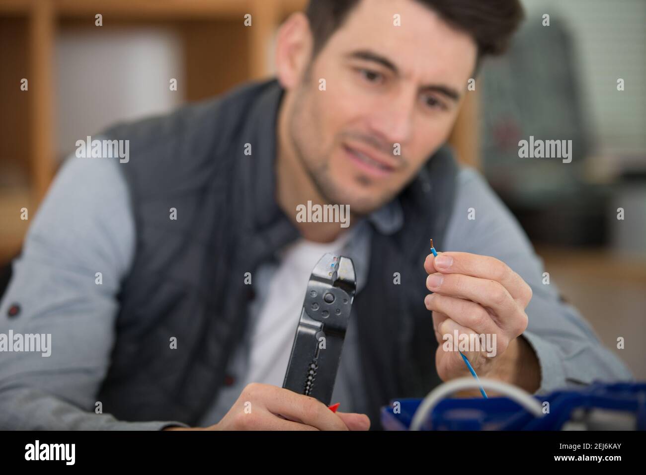 male electrician holding cable cutters and blue cable Stock Photo - Alamy
