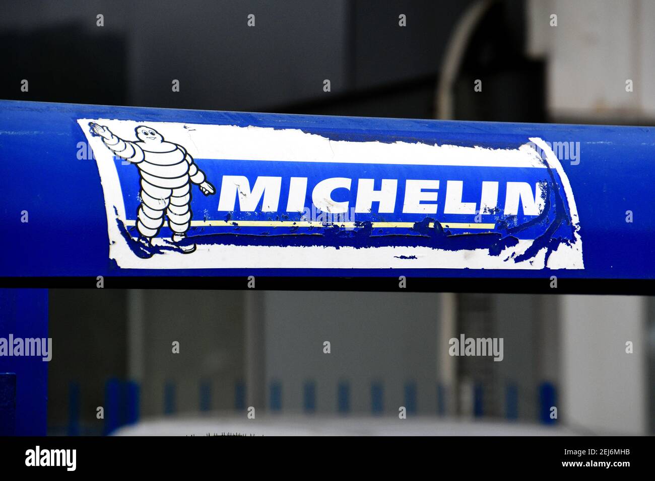 Michelin company logo seen on a tire display in front of an auto garage ...