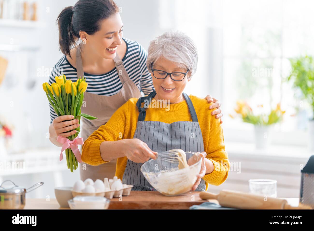 Happy family in the kitchen. Mother and her adult daughter are ...