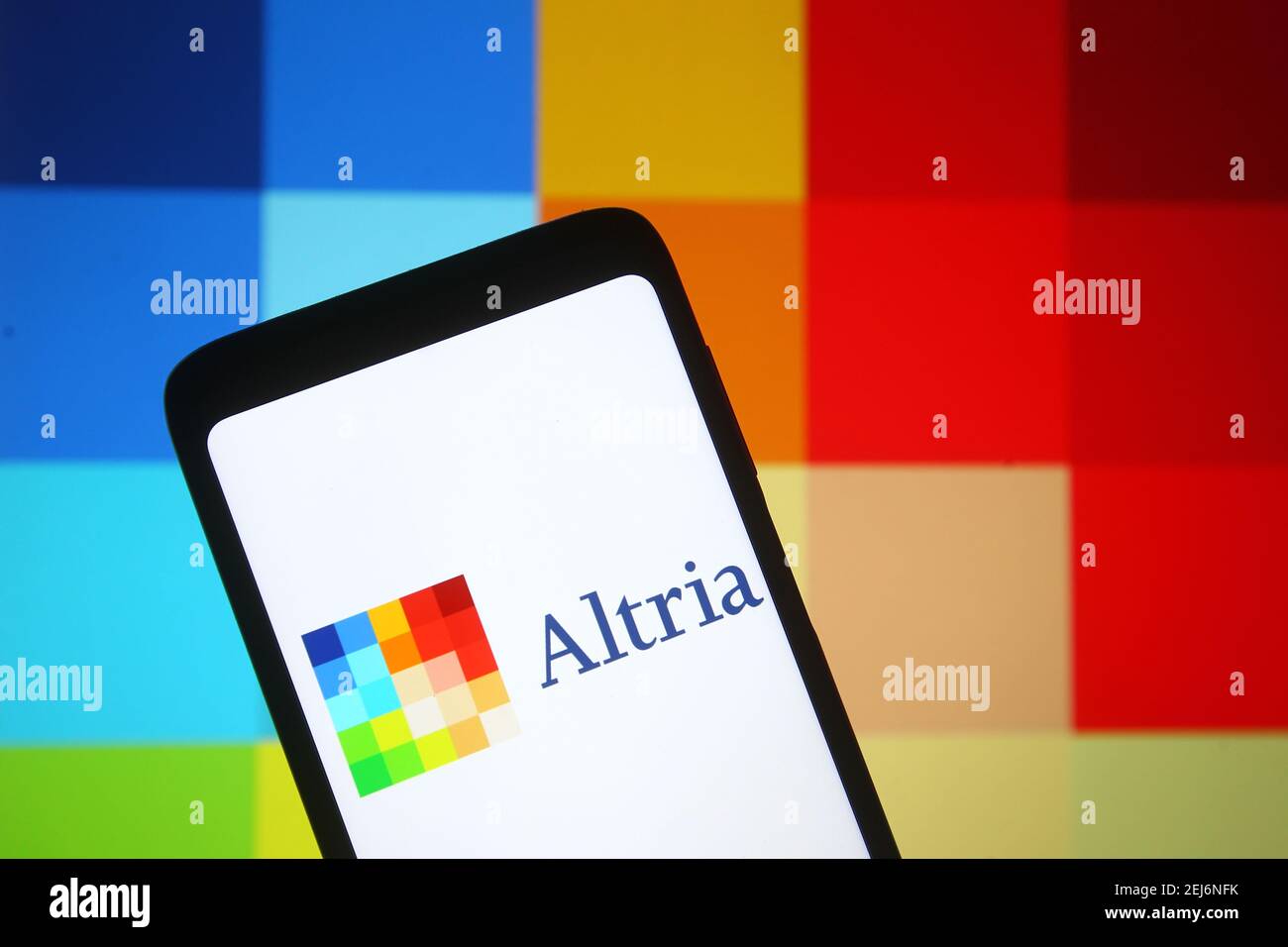 In this photo illustration an Altria logo is seen on a smartphone and a ...