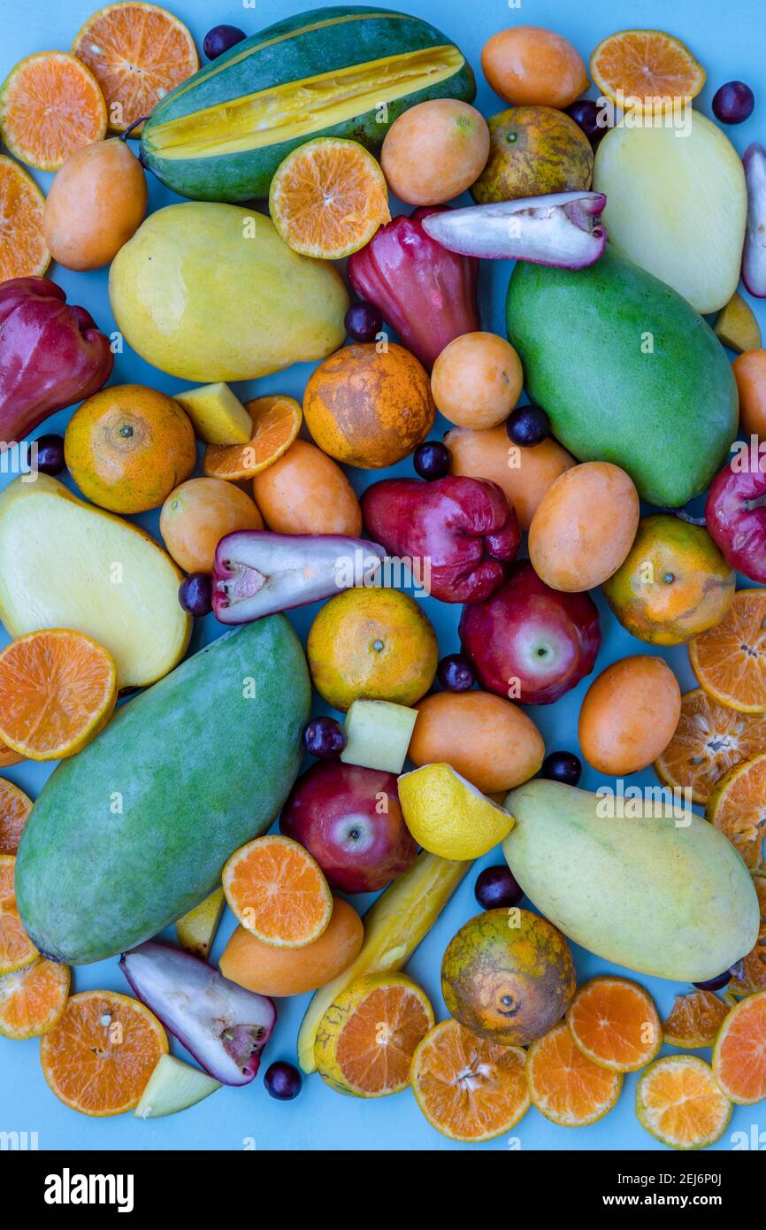 Variety of fresh assorted fruits on blue background. Assorted fruits ...