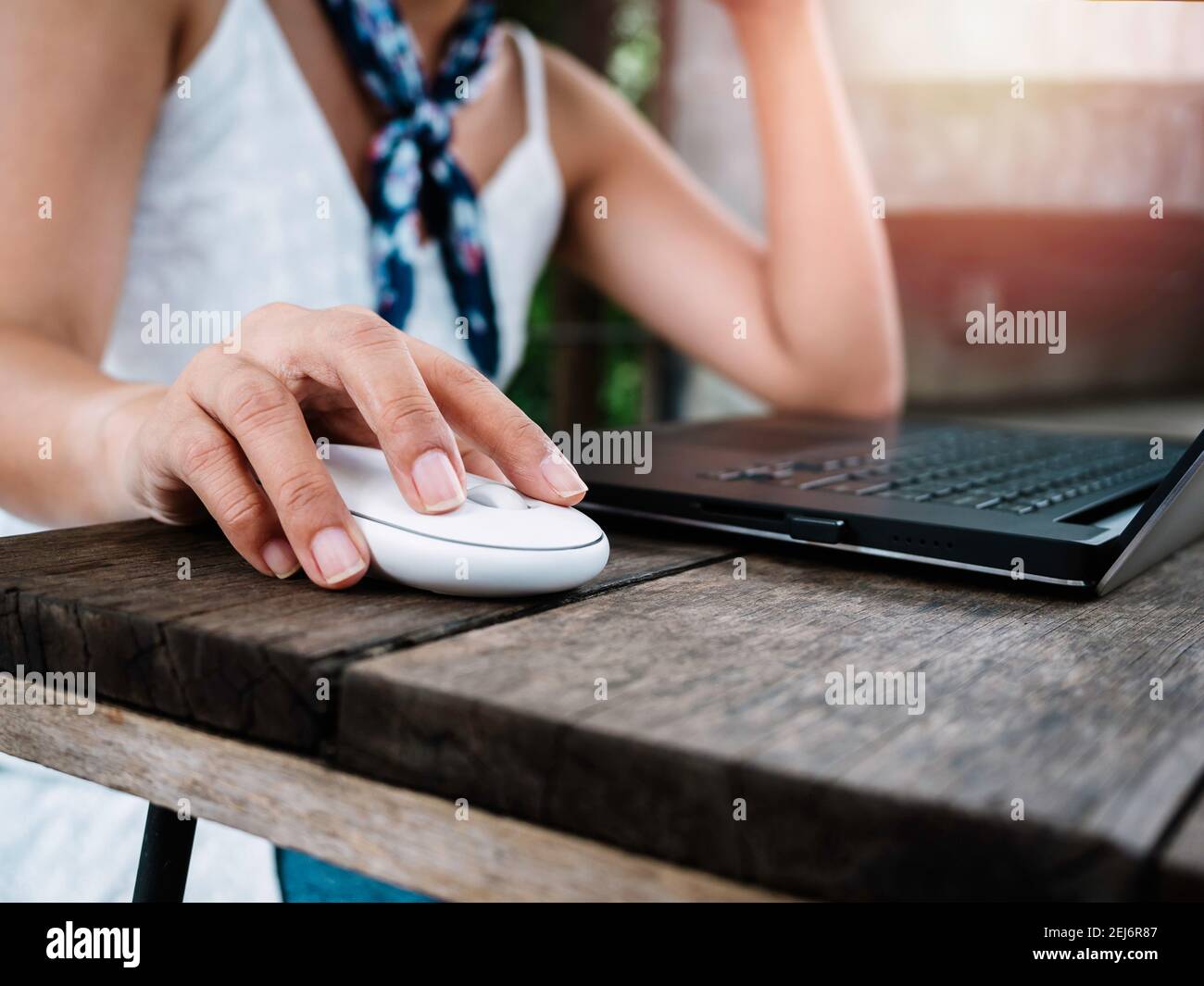 Finger using modern white wireless mouse while working on black laptop ...
