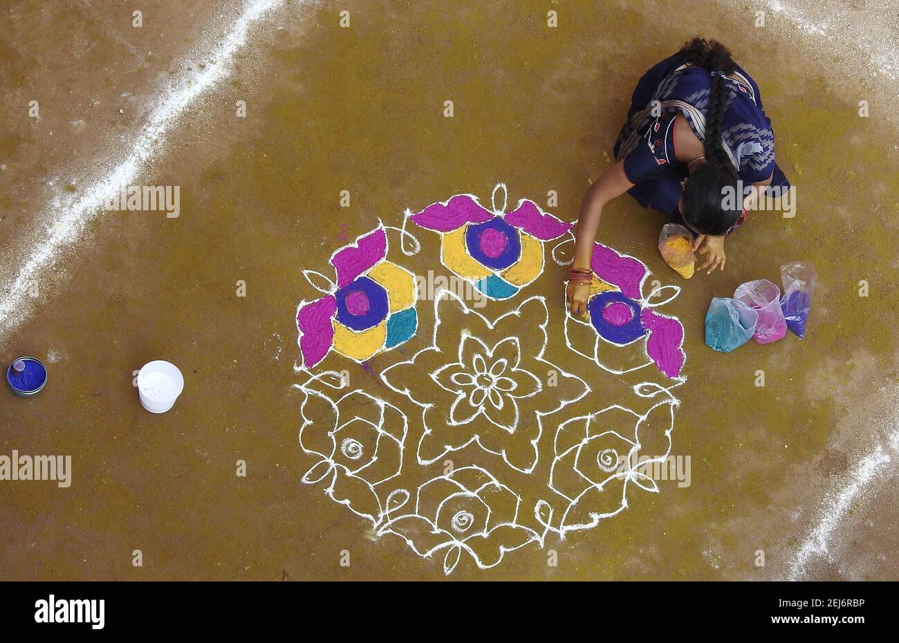 Indian Hindu woman draw traditional rangoli during harvest festival ...