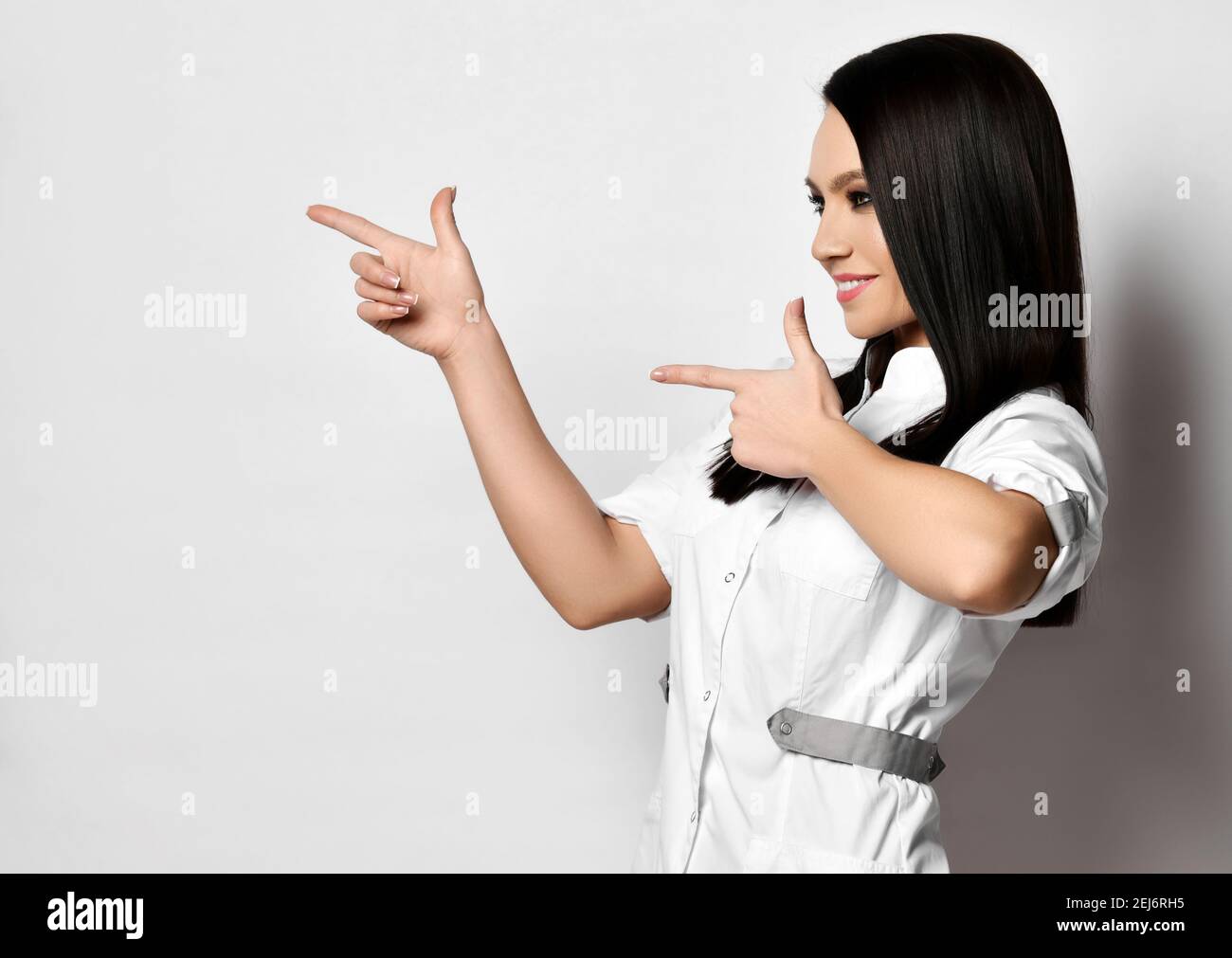 Young smiling woman doctor nurse in medical uniform stands sideways to ...