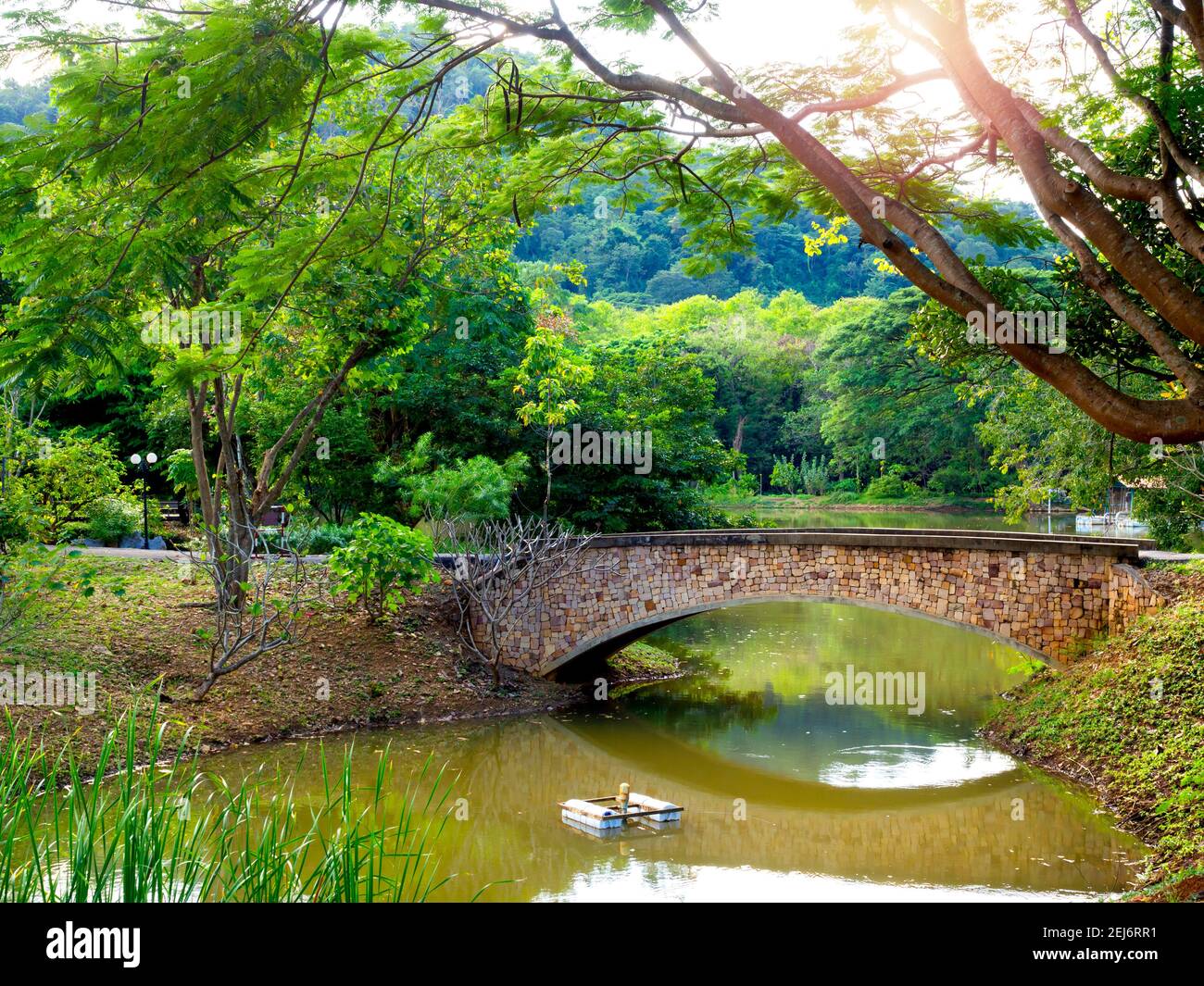 Stone bridge crosses a stream near the mountain. Old vintage brick ...