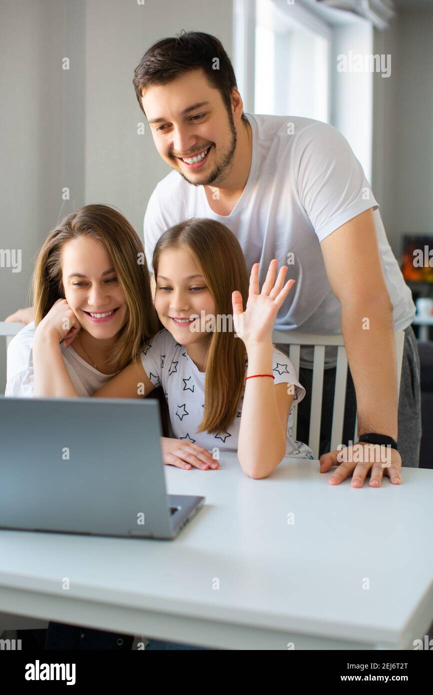 Vertical photo of a happy family during an online video call ...