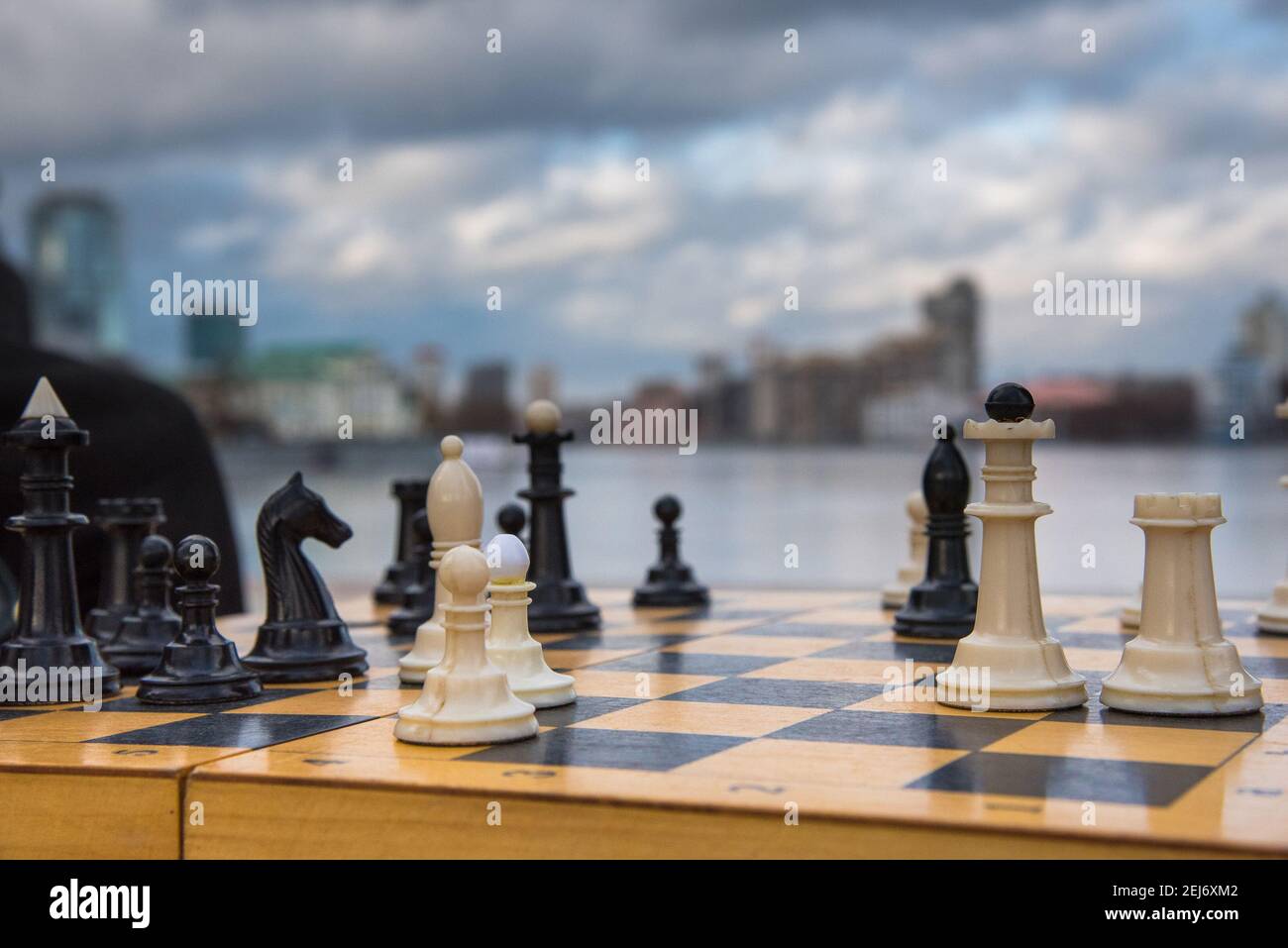 Party game white and black chess pieces on a wooden board against the ...