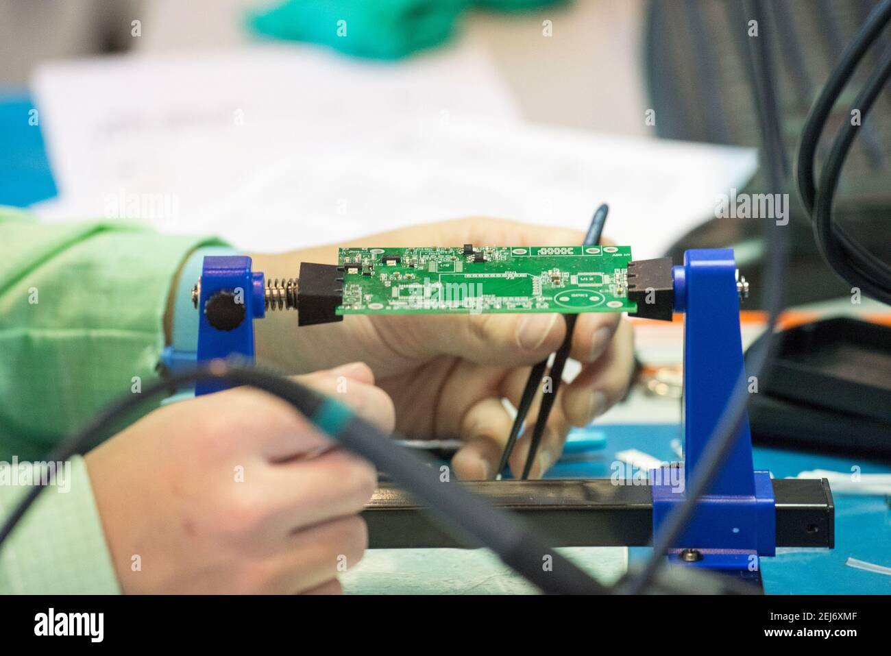 A person selects and solder the parts of the chip with a soldering iron ...
