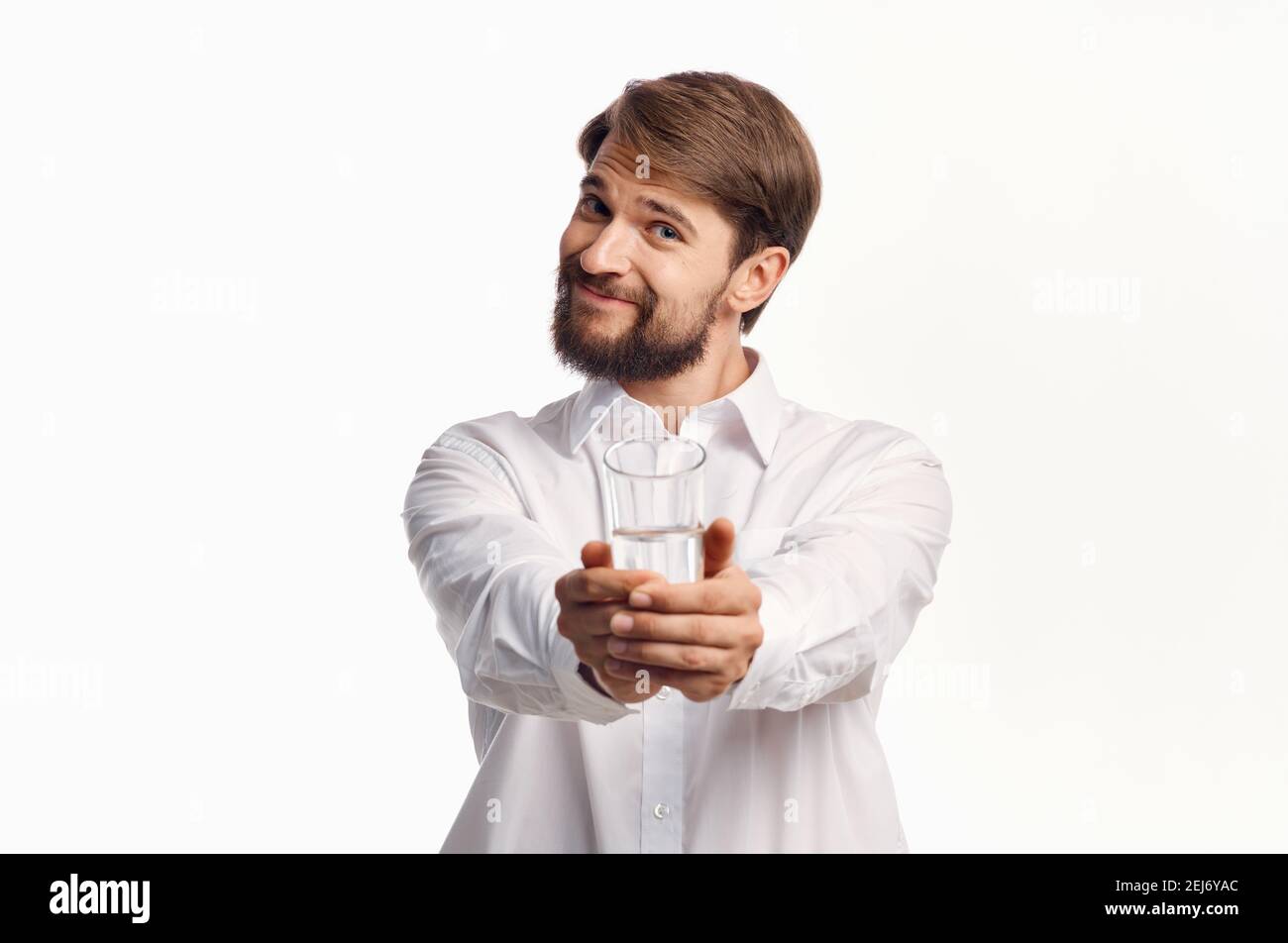 joyful man stretches out his hand with a glass of water forward on a ...