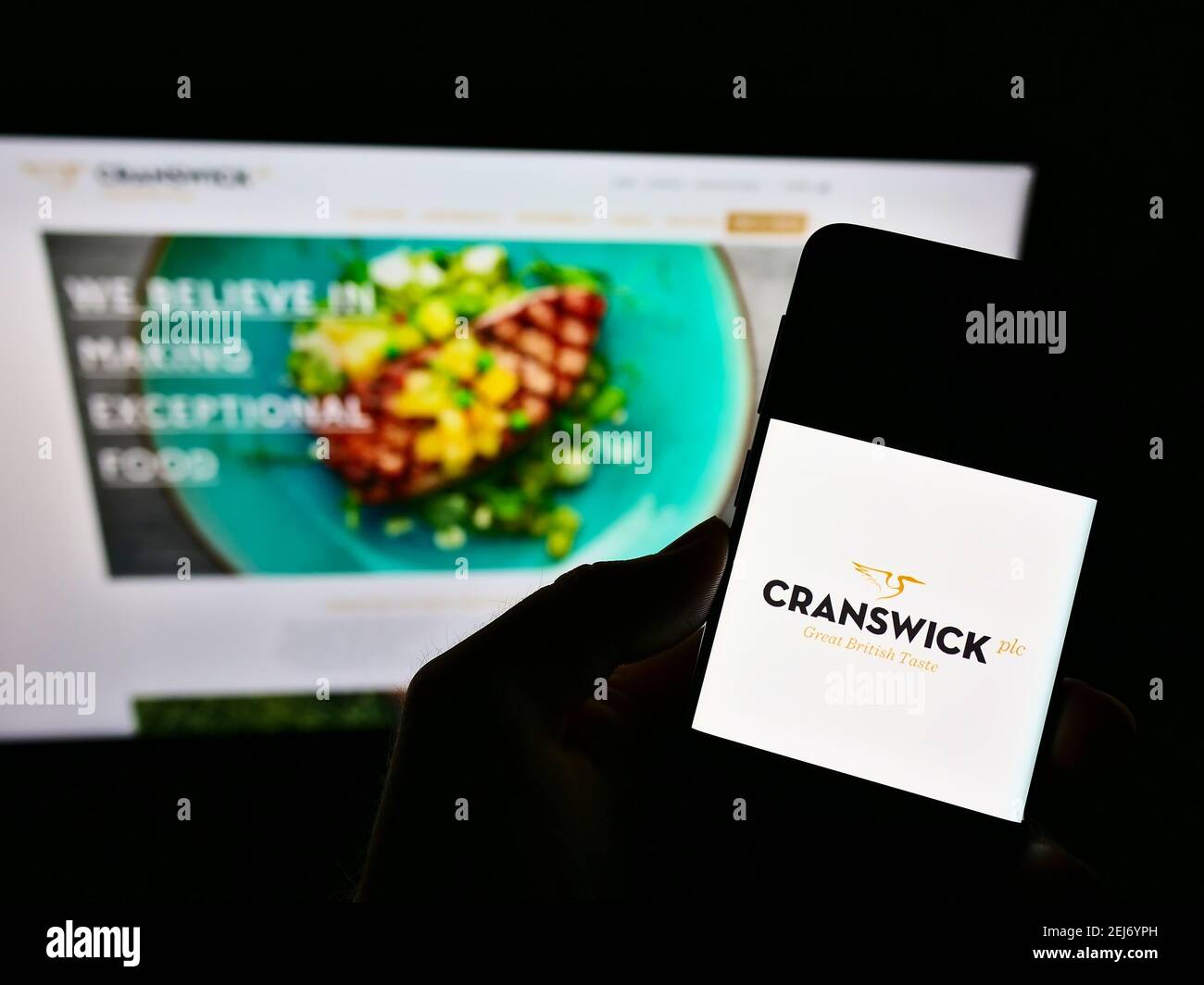 Person holding smartphone with logo of British food producing company ...