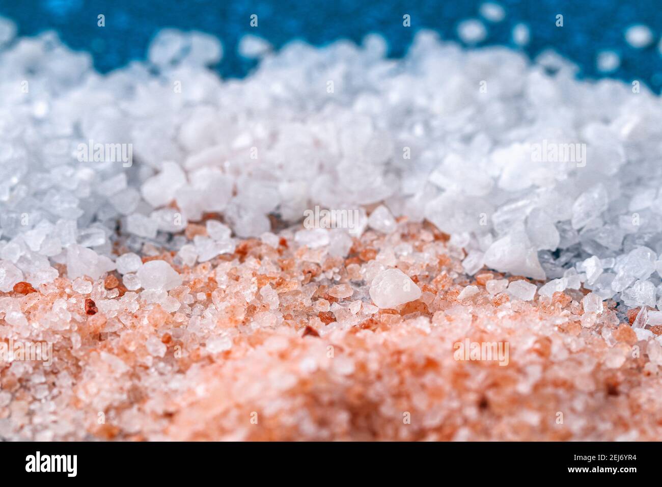 Pink coarse salt crystals on a blue table. Himalaya salt. Background ...