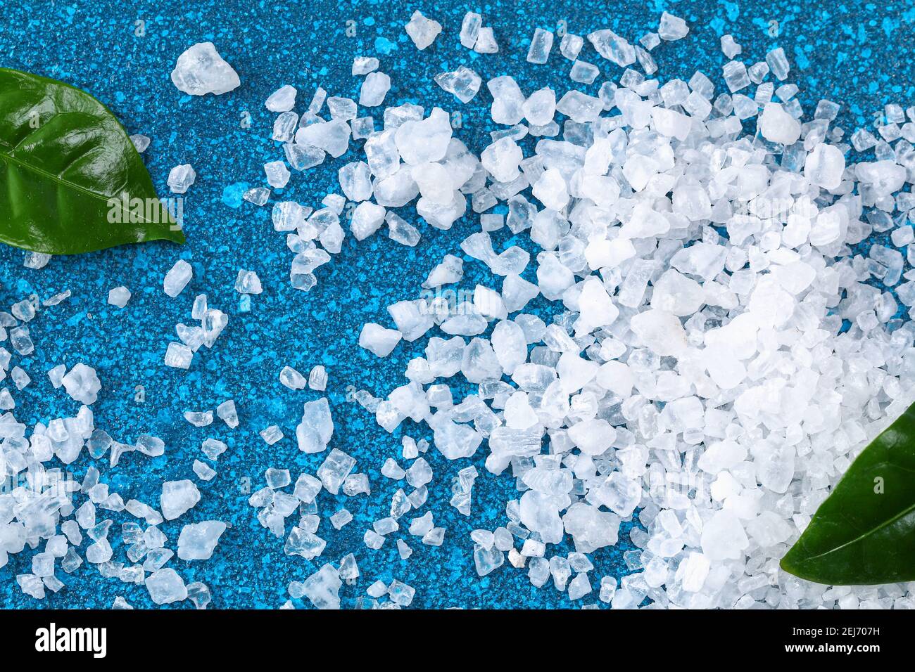 Coarse salt crystals on a blue table. sea salt. Background for ...