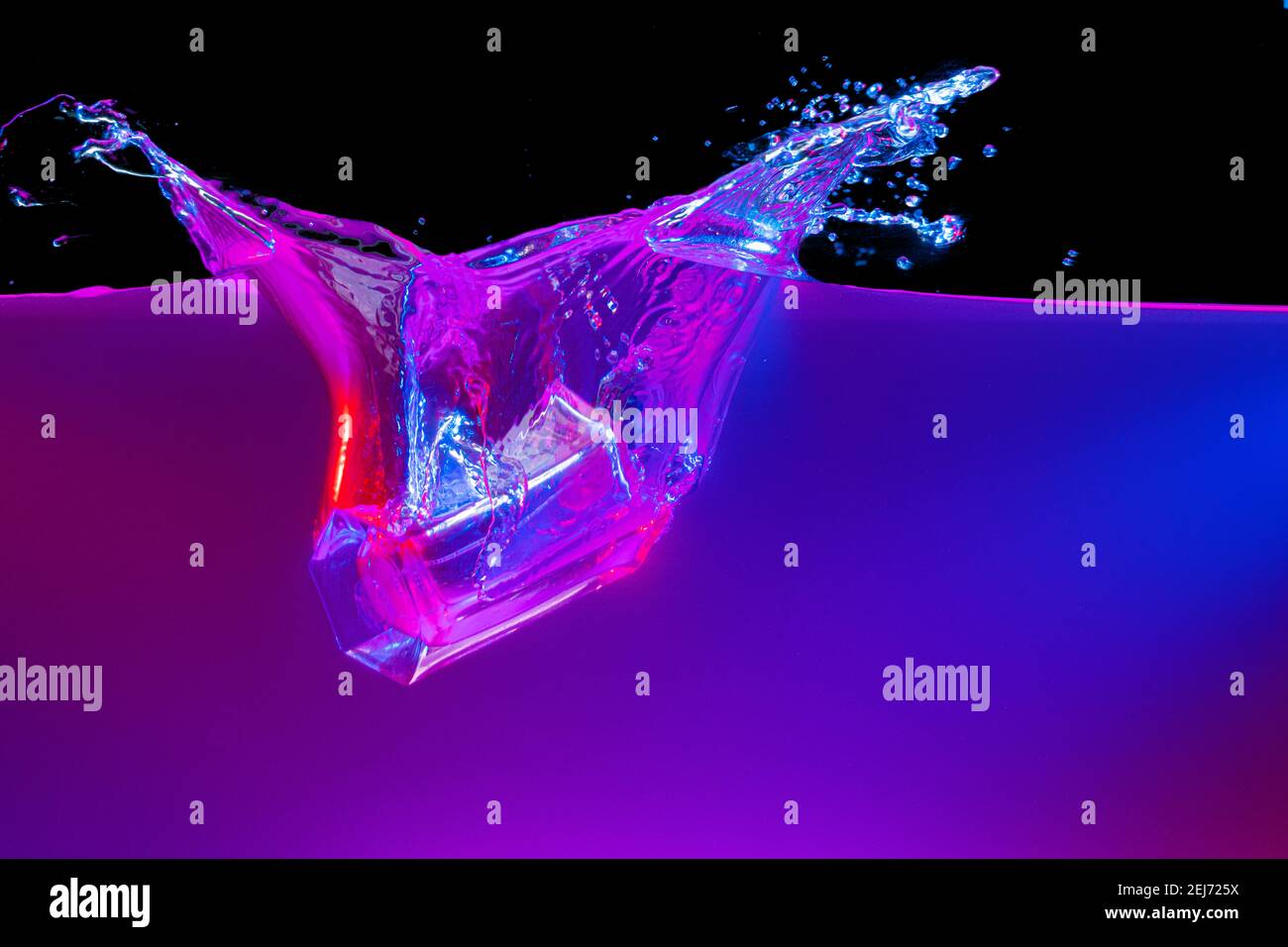 Perfume bottle diving into the water with a splash in neon light Stock ...