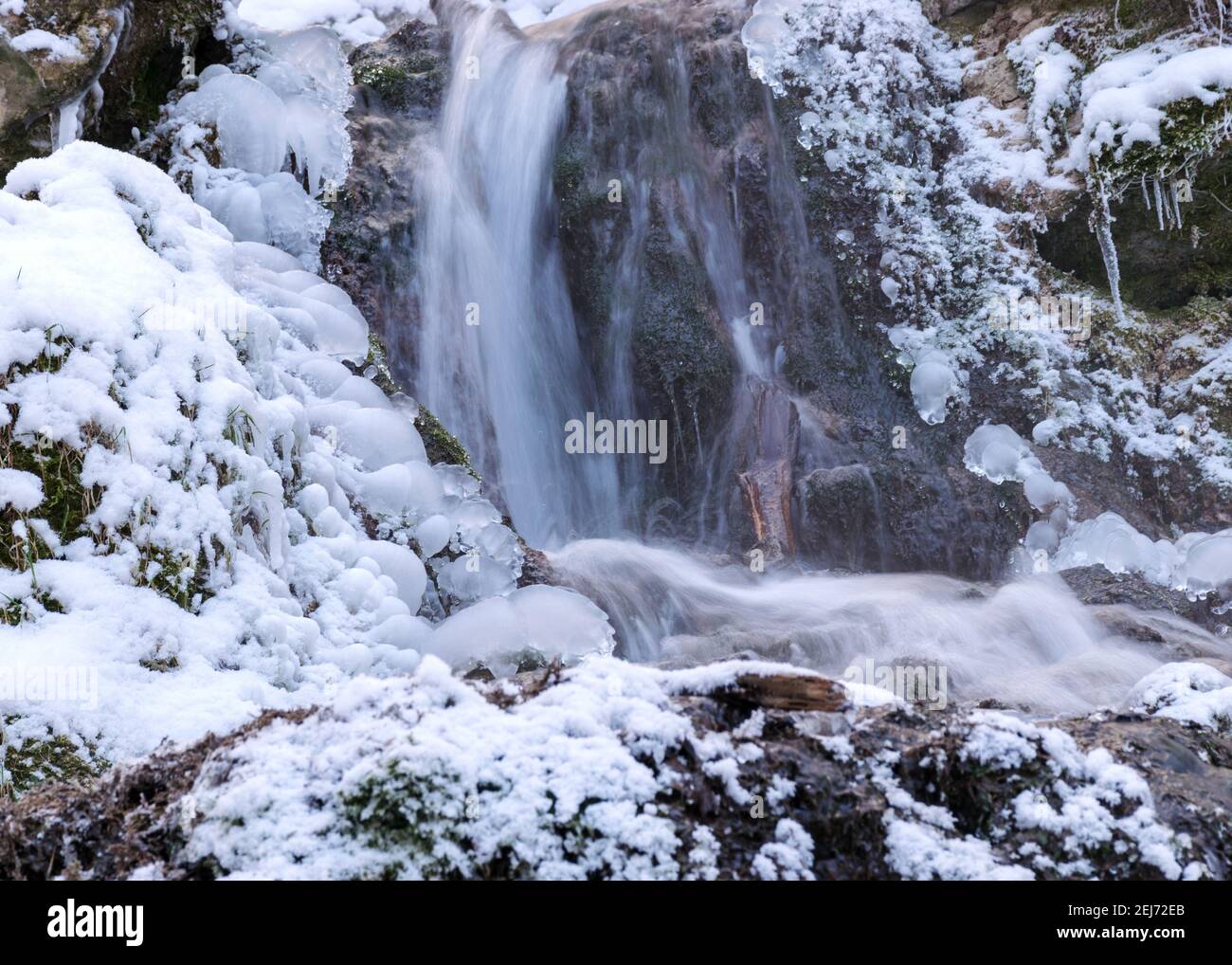 frozen fast flowing spring water, icy rocks and water stream, frosty ...