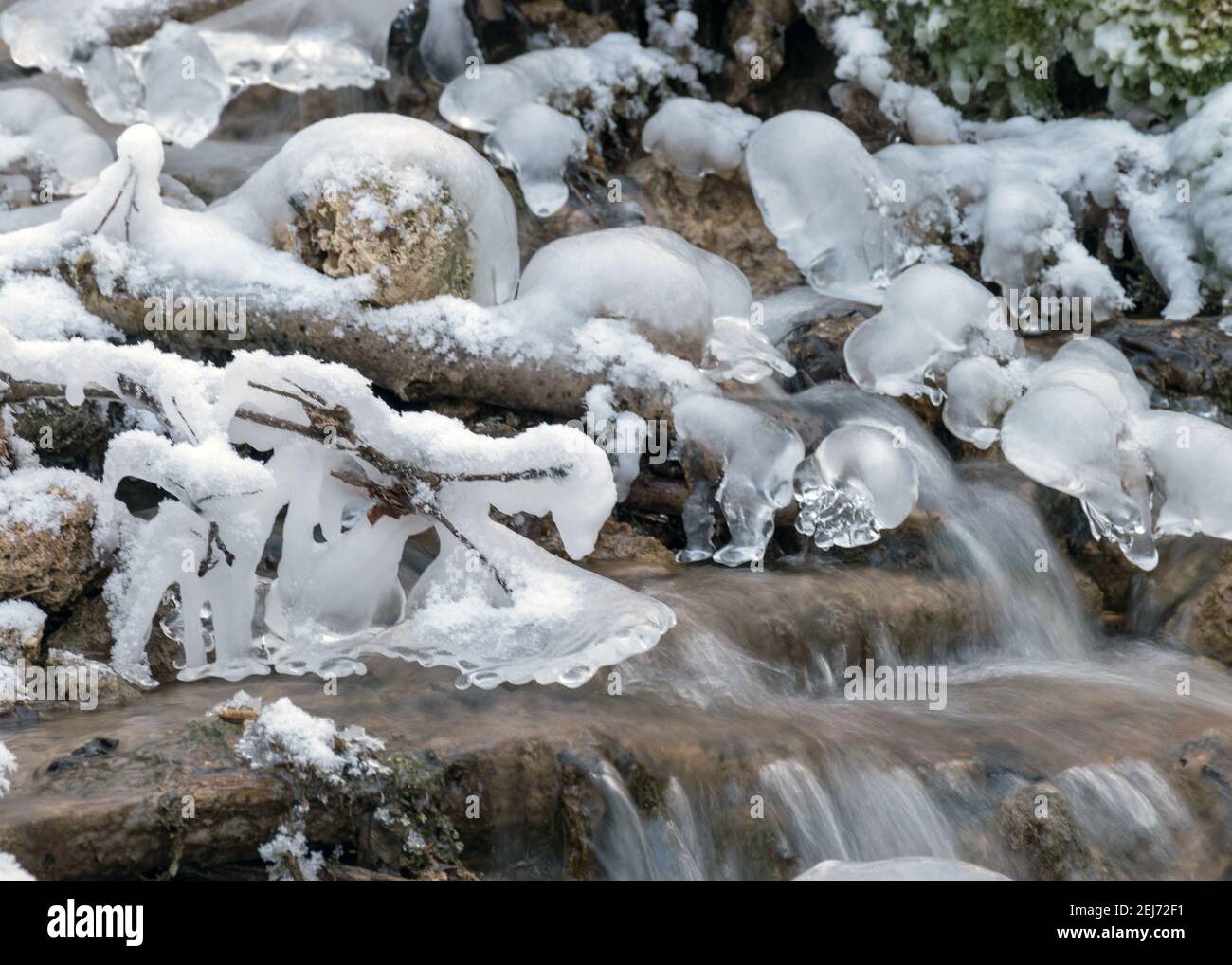 frozen fast flowing spring water, icy rocks and water stream, frosty ...