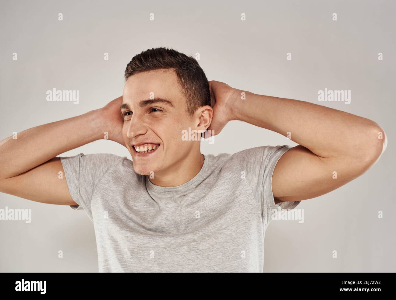 cheerful man gesturing with his hands in a white t-shirt light ...