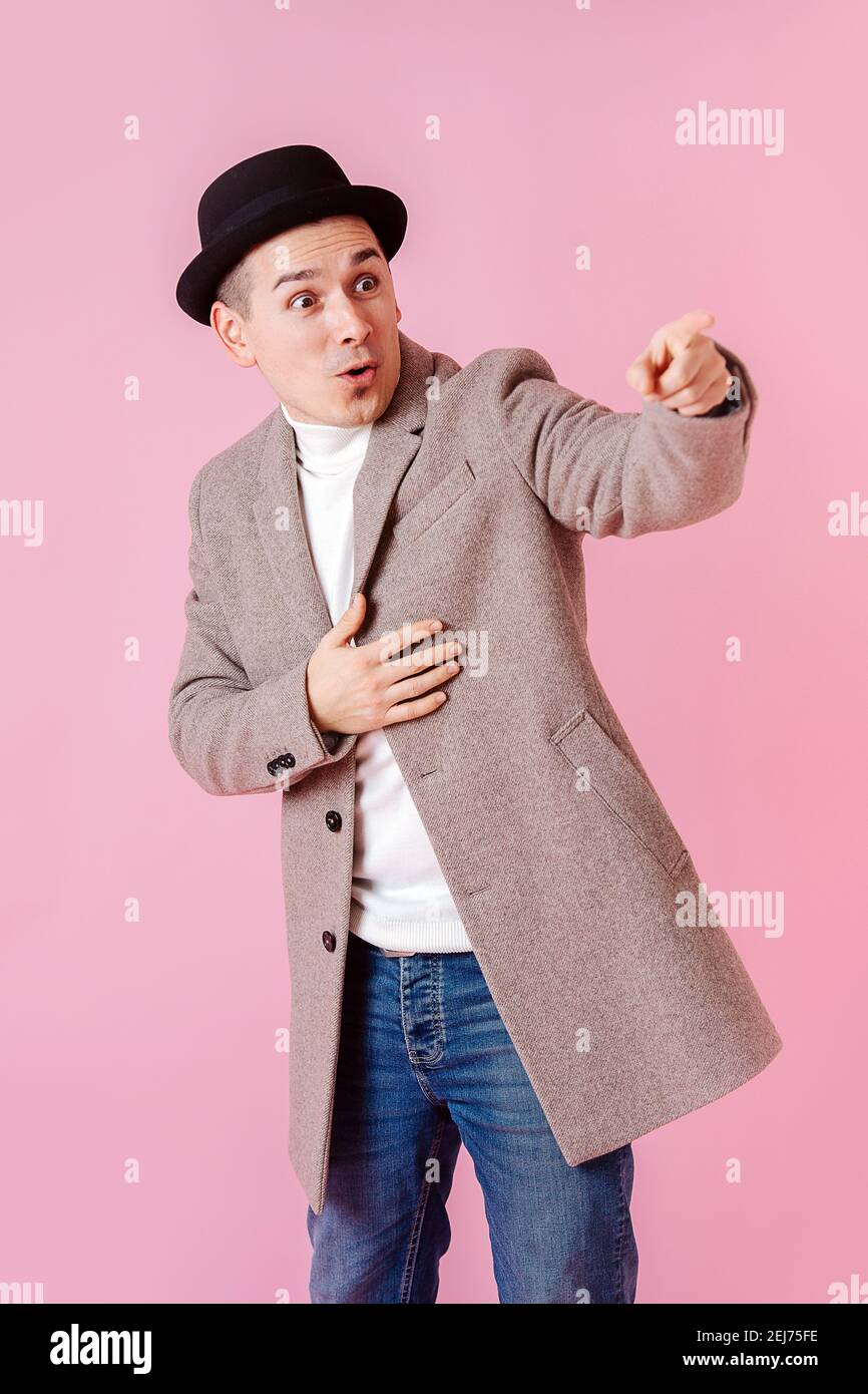 Alert man dressed in a coat and a classical porkpie hat points at ...