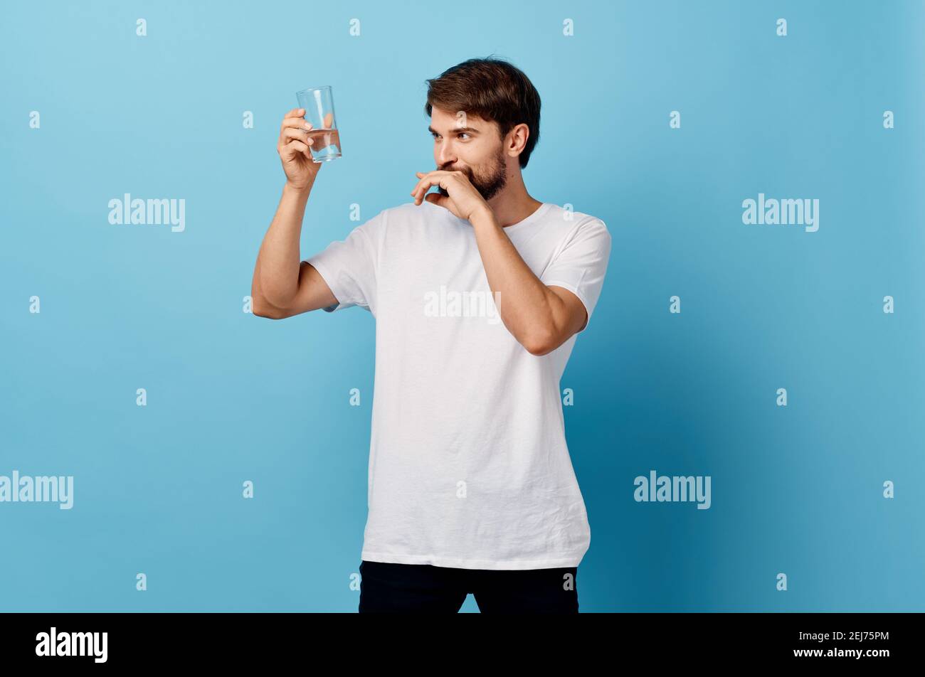 man testing water in a glass on blue background lifestyle drink cropped ...