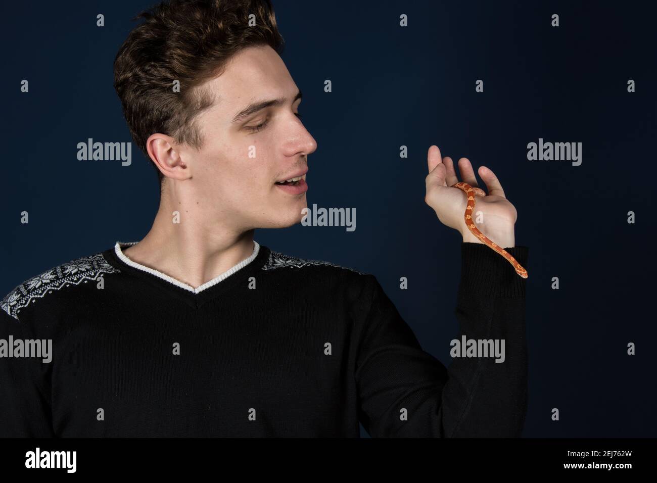 Attractive young guy with a snake Stock Photo - Alamy