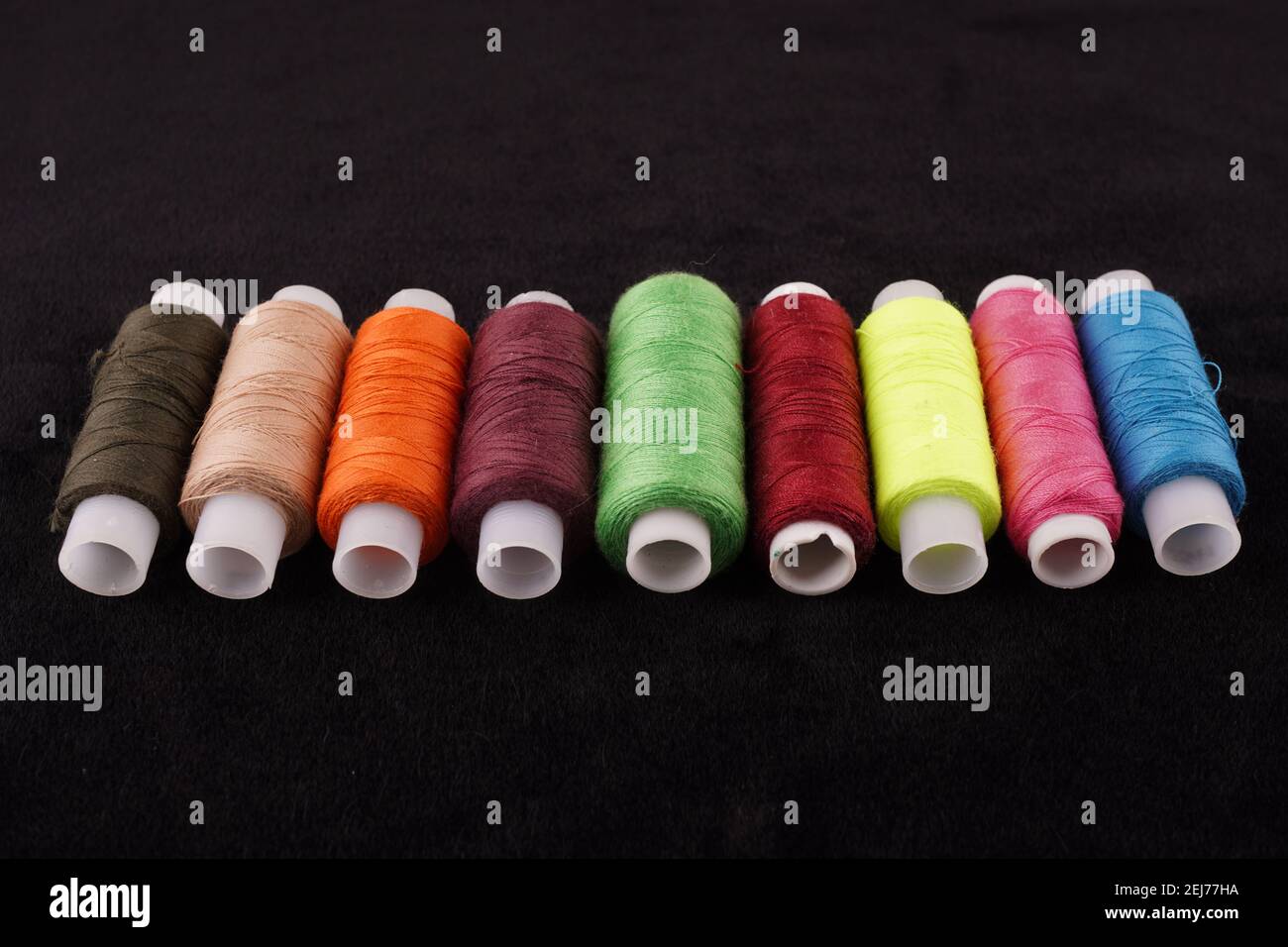 colored threads on a black background Stock Photo - Alamy