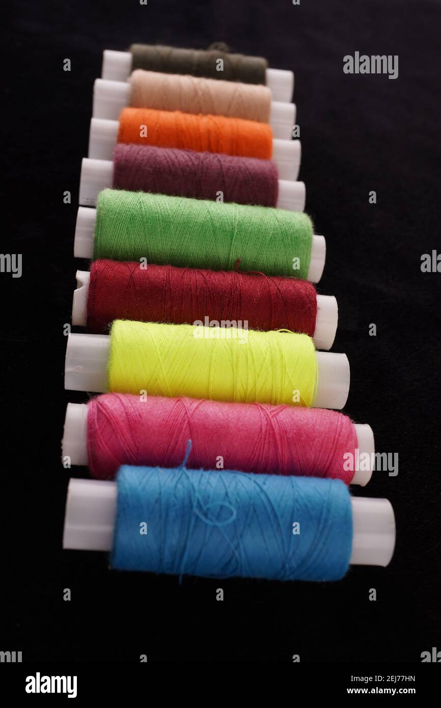colored threads on a black background Stock Photo - Alamy