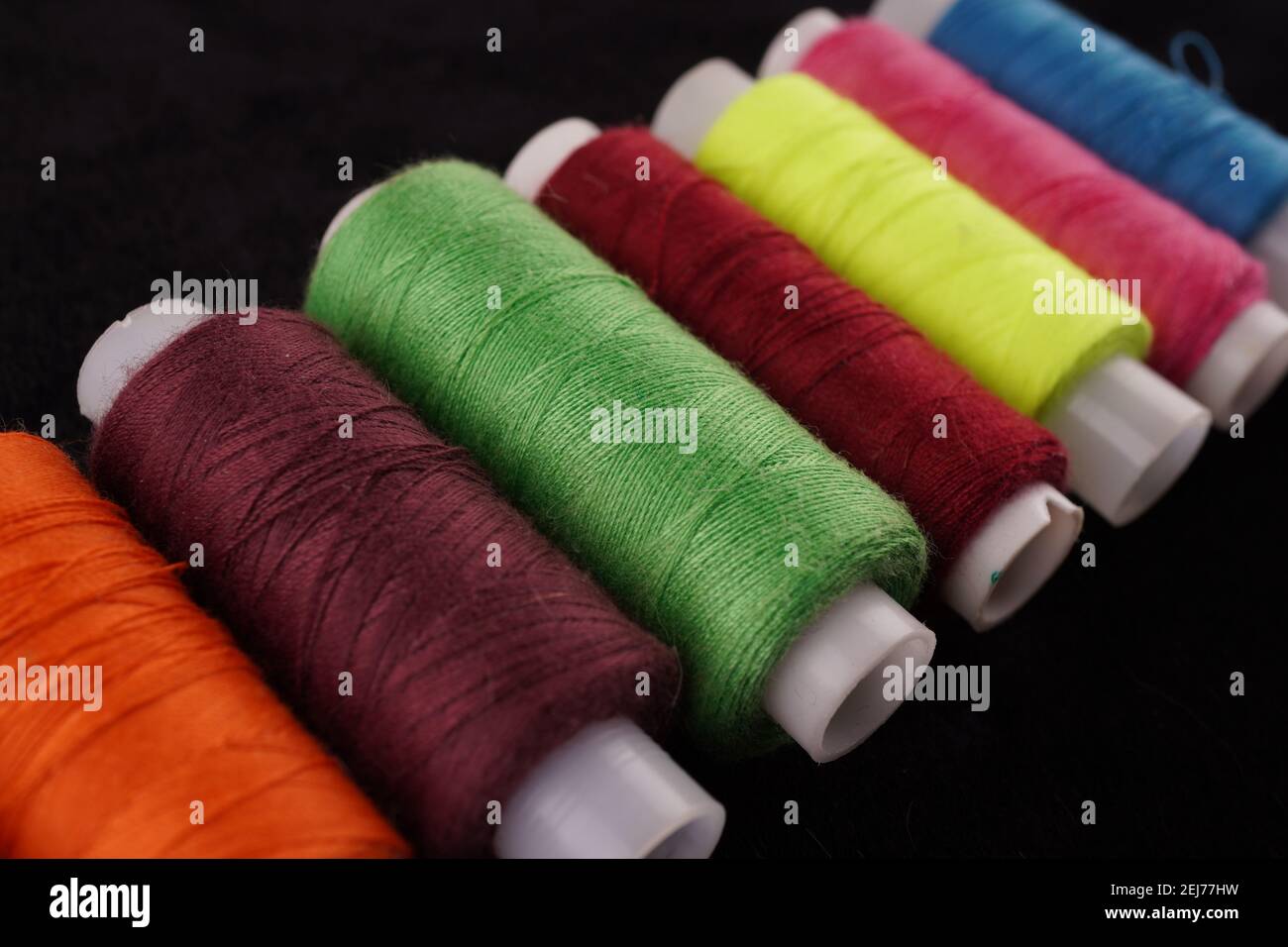 colored threads on a black background Stock Photo - Alamy