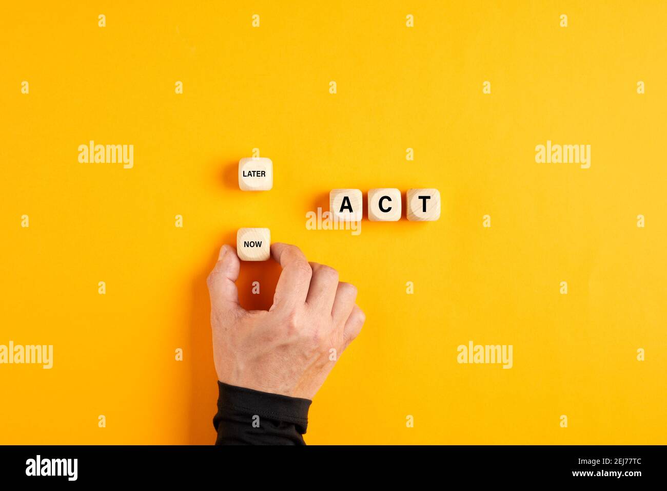 The word act on wooden blocks with a male hand choosing the now option ...