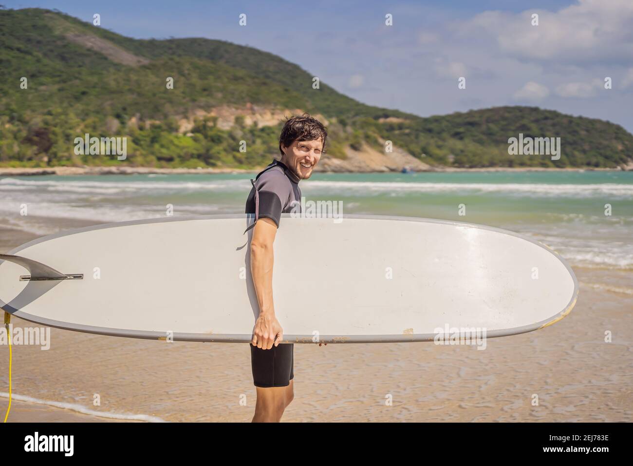 Young surfer standing agains the ocean looking the waves, professional ...