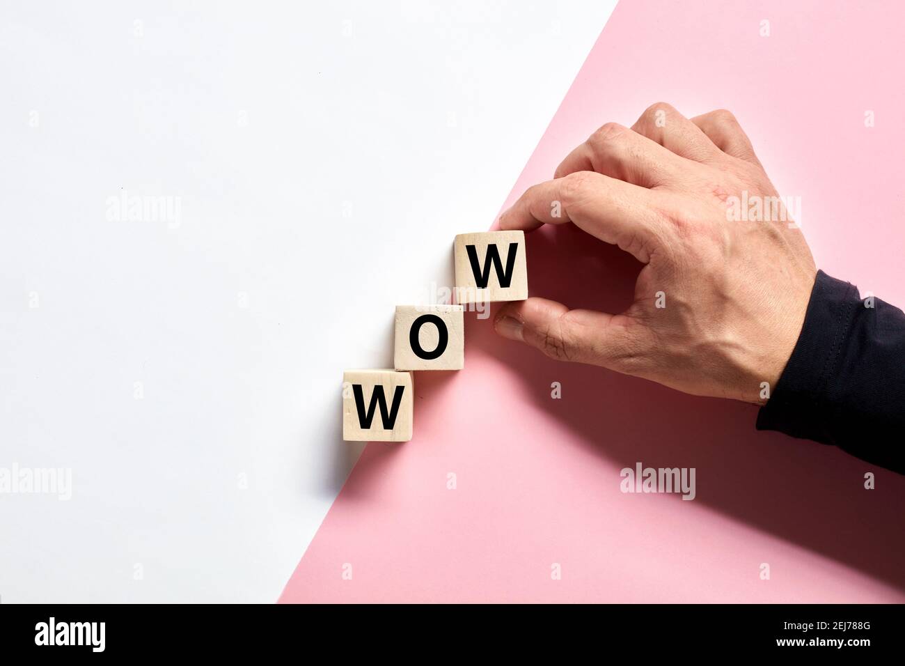 Male hand arranging the wooden cubes with the word WOW. Expression of ...