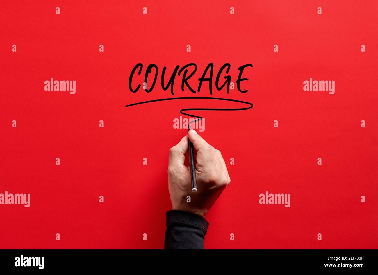 Male hand writing the word courage on red background. Courage and risk ...