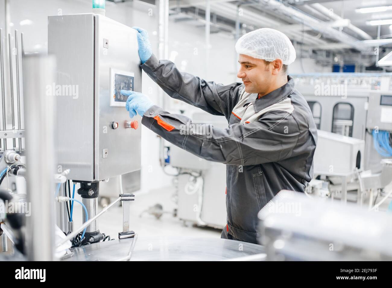 Factory engineer man operating machine control panel in dairy milk ...